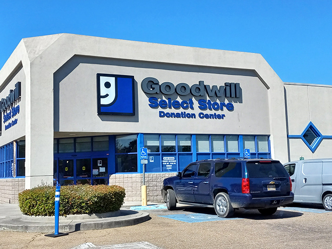 The iconic blue-and-white Goodwill Select Store facade stands ready to welcome treasure hunters under the Mississippi sun. 