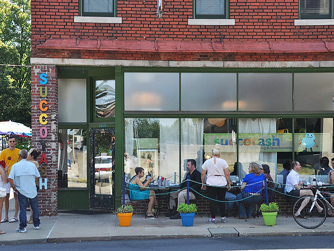 The iconic brick facade of Succotash welcomes hungry souls with its vintage vertical signage and promise of comfort food extraordinaire.
