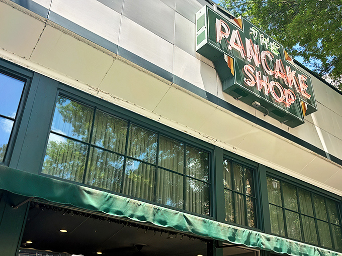 The iconic green awning and vintage sign of The Pancake Shop stands as a breakfast beacon on Hot Springs' Central Avenue, promising morning magic within.