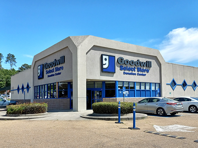 The iconic blue-and-white Goodwill Select Store facade stands ready to welcome treasure hunters under the Mississippi sun. 