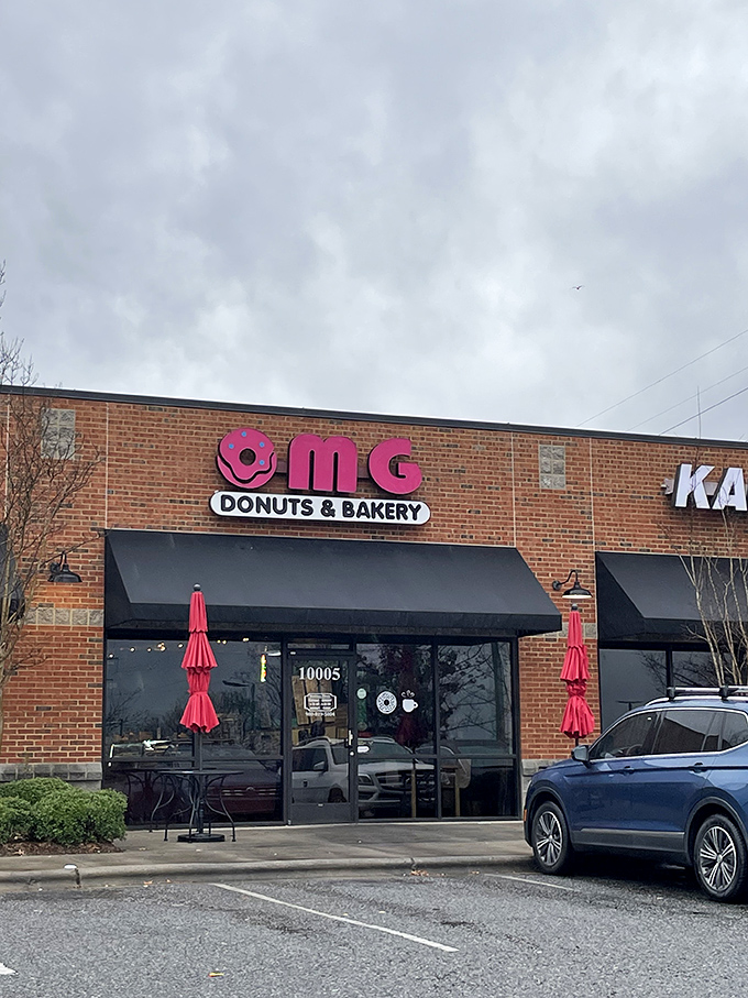 The pink donut sign beckons like a sugary lighthouse, promising sweet salvation for carb enthusiasts in Concord's unassuming strip mall.