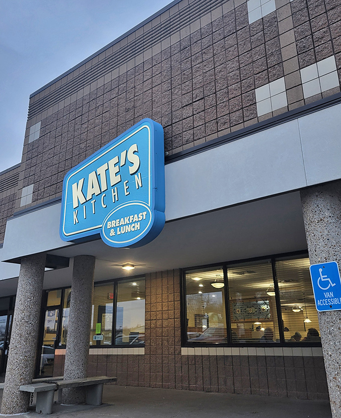 The blue sign beckons like a breakfast lighthouse, guiding hungry souls to Kate's Kitchen where morning miracles await in tortilla-wrapped glory.