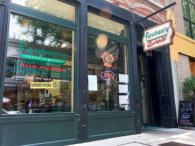 The historic brick façade of Reuben's Deli stands as a beacon for sandwich aficionados. That vintage sign promises delicious things await inside.