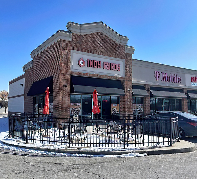 The brick fa&ccedil;ade of Indy Gyros stands like a beacon of Mediterranean hope in a sea of chain restaurants. Those red umbrellas practically whisper, "Slow down, hungry traveler."