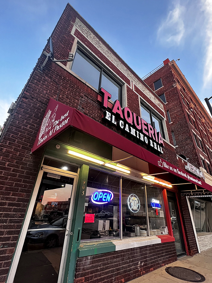 The glowing red "TAQUERIA" sign against brick isn't just signage&mdash;it's a beacon of hope for hungry souls seeking authentic Mexican flavors in Kansas City.