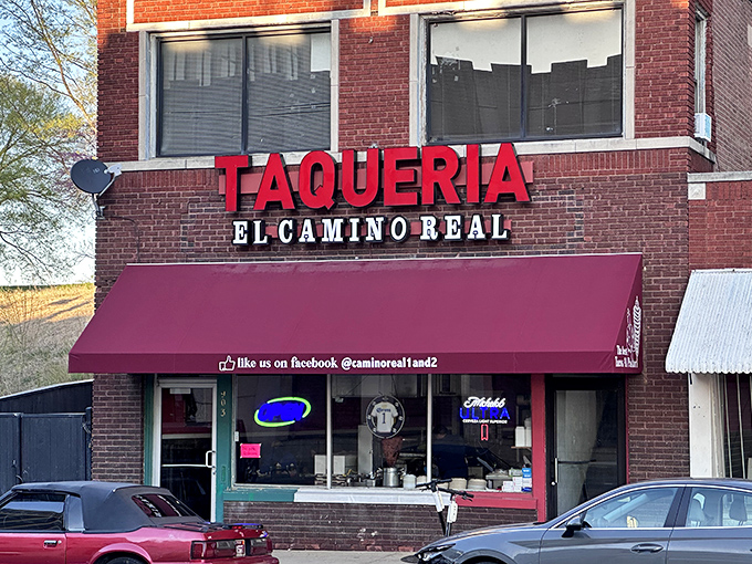 The glowing red "TAQUERIA" sign against brick isn't just signage&mdash;it's a beacon of hope for hungry souls seeking authentic Mexican flavors in Kansas City.