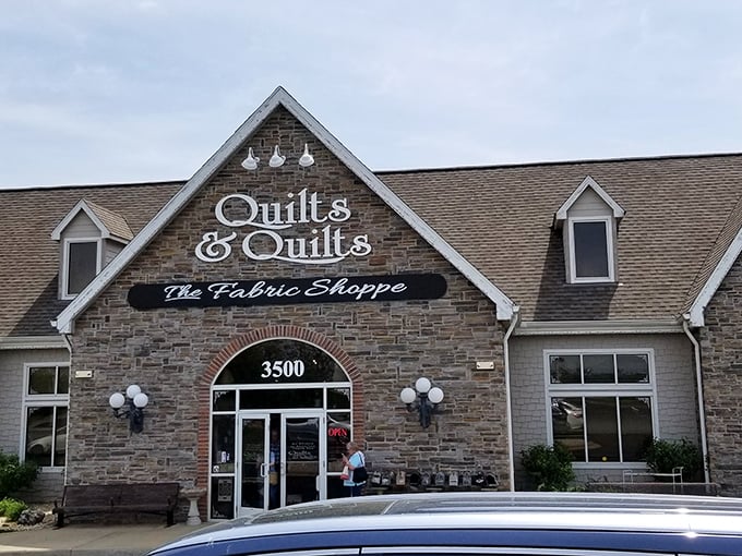 The stone facade of Quilts & Quilts stands like a crafting castle in Branson, beckoning fabric enthusiasts with promises of textile treasures within.