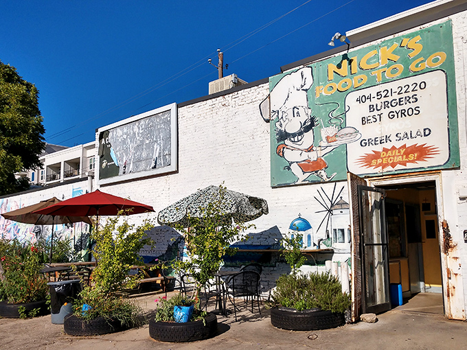 The unassuming white brick fa&ccedil;ade of Nick's Food To Go stands like a culinary lighthouse in Atlanta's urban landscape, beckoning hungry souls with its vintage sign.