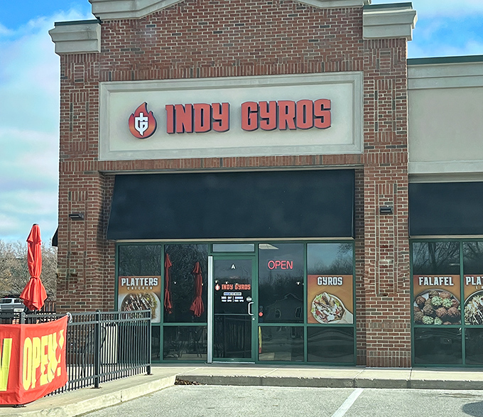 The brick fa&ccedil;ade of Indy Gyros stands like a beacon of Mediterranean hope in a sea of chain restaurants. Those red umbrellas practically whisper, "Slow down, hungry traveler."