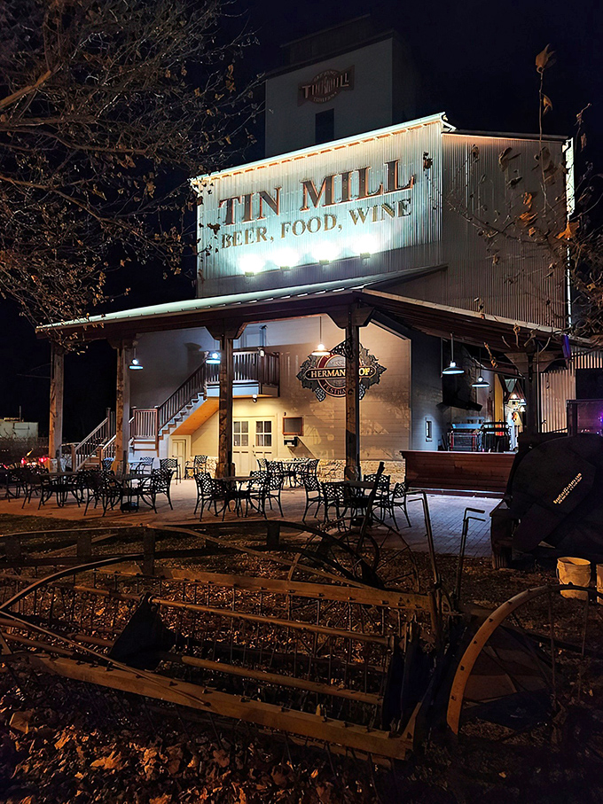 The iconic white exterior of Tin Mill Restaurant stands tall against the Missouri night sky, promising German-American delights inside this converted historic building.