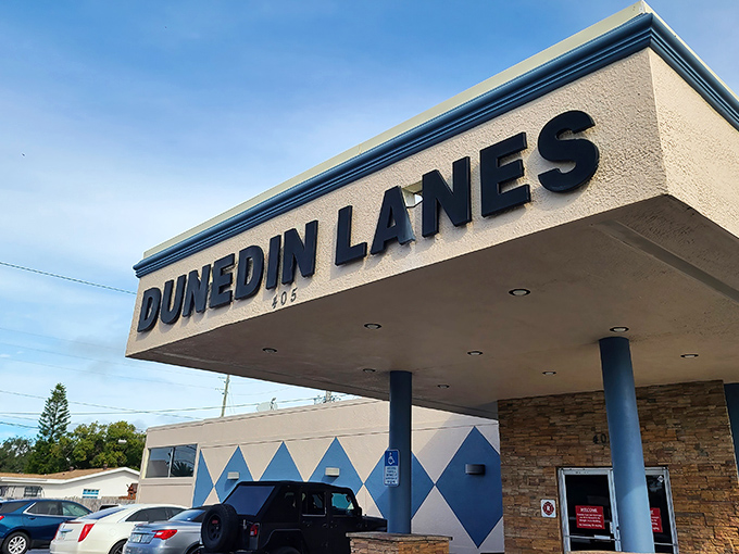 The classic neon-lit entrance to Dunedin Lanes beckons like a portal to simpler times when entertainment didn't require a Wi-Fi password.