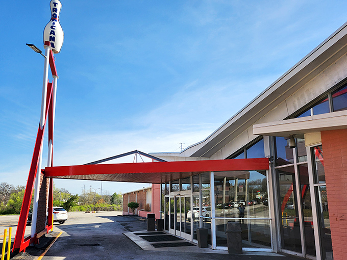The iconic A-frame entrance of Tropicana Lanes stands like a mid-century time portal, complete with that space-age bowling pin perched proudly on top.