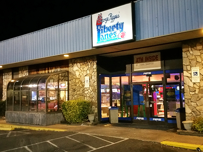 The classic stone facade and iconic blue signage of Liberty Lanes stands as a time capsule of American recreation—where memories are made one frame at a time.