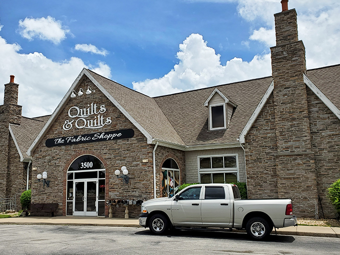 The stone facade of Quilts & Quilts stands like a crafting castle in Branson, beckoning fabric enthusiasts with promises of textile treasures within. 