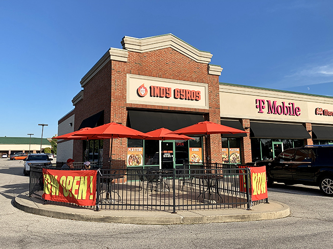 The brick fa&ccedil;ade of Indy Gyros stands like a beacon of Mediterranean hope in a sea of chain restaurants. Those red umbrellas practically whisper, "Slow down, hungry traveler."