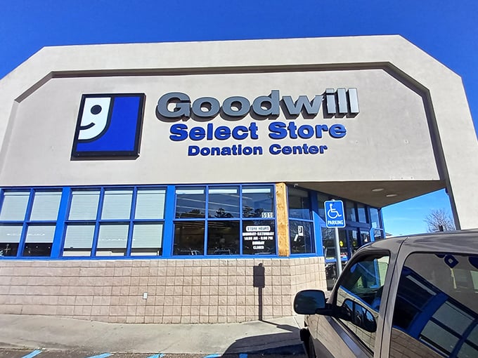 The iconic blue-and-white Goodwill Select Store facade stands ready to welcome treasure hunters under the Mississippi sun.