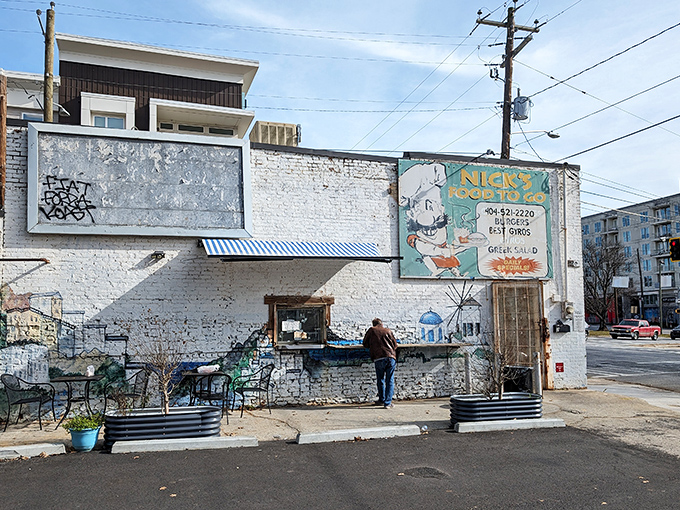 The unassuming white brick fa&ccedil;ade of Nick's Food To Go stands like a culinary lighthouse in Atlanta's urban landscape, beckoning hungry souls with its vintage sign.