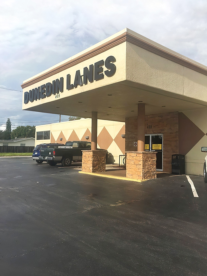 The classic neon-lit entrance to Dunedin Lanes beckons like a portal to simpler times when entertainment didn't require a Wi-Fi password.