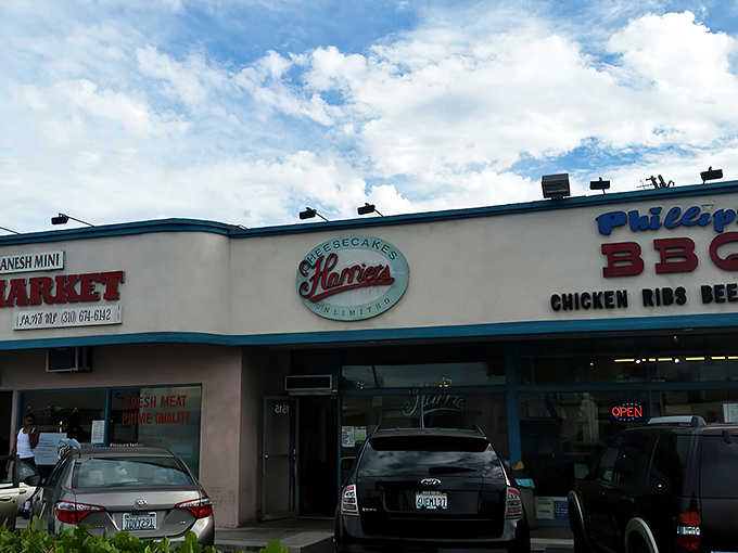 The unassuming storefront of Harriet's Cheesecakes Unlimited in Inglewood &ndash; proof that culinary greatness often hides in plain sight behind modest blue trim.