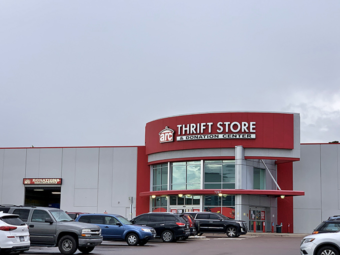 The bold red entrance of Arc Thrift Store beckons like a retail lighthouse, promising treasure hunters the thrill of discovery within its cavernous interior.