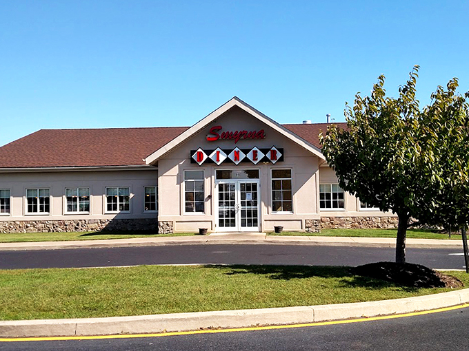 The Smyrna Diner stands proudly against a blue Delaware sky, its cream-colored exterior and distinctive sign promising comfort food salvation to hungry travelers and locals alike.
