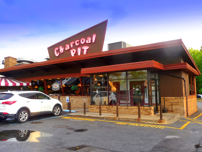 The iconic red neon sign of Charcoal Pit glows like a beacon of burger hope on Concord Pike, promising a time-traveling culinary adventure since 1956.