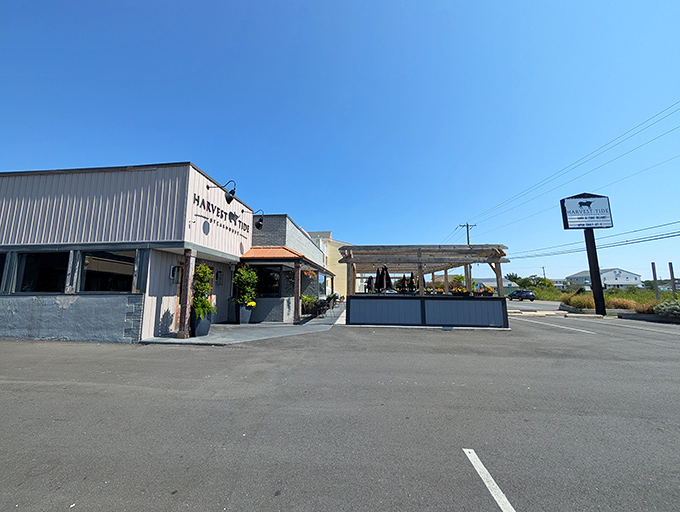 The coastal charm of Harvest Tide Steakhouse beckons from its light-colored exterior, where wooden doors promise carnivorous delights within.