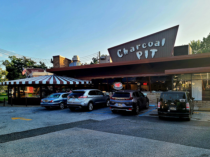 The iconic red neon sign of Charcoal Pit glows like a beacon of burger hope on Concord Pike, promising a time-traveling culinary adventure since 1956.