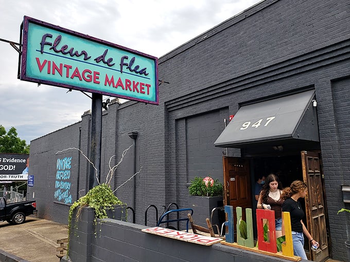 The turquoise sign beckons like a vintage siren song, promising treasures behind those brick walls that your modern big-box stores couldn't dream of housing.