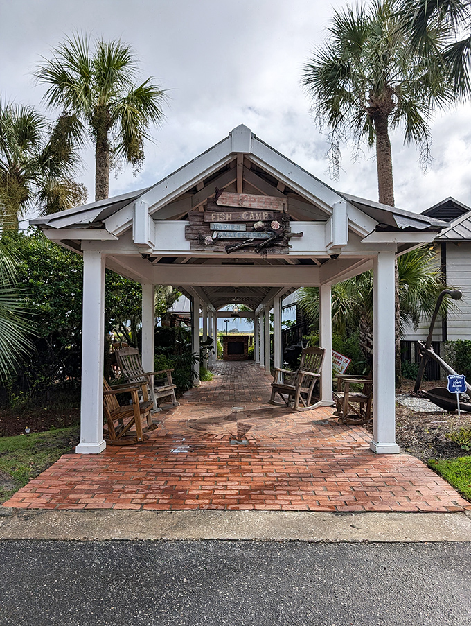 The entrance to seafood paradise! Palm trees stand guard as wooden rocking chairs invite you to slow down before the feast begins.