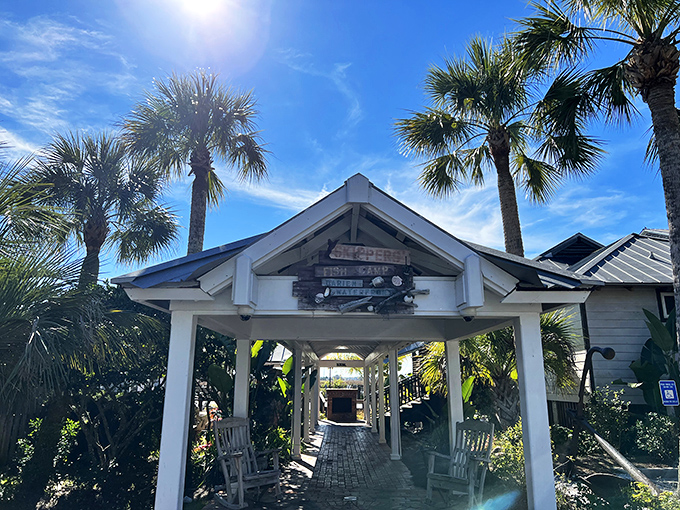 The entrance to seafood paradise! Palm trees stand guard as wooden rocking chairs invite you to slow down before the feast begins.