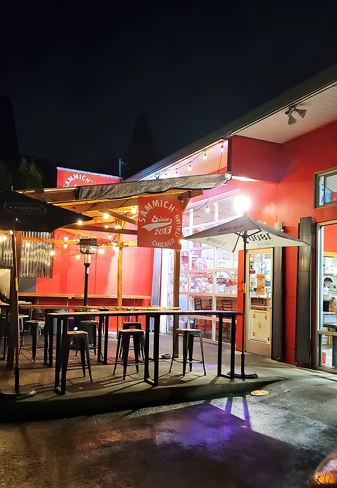 The vibrant red exterior of Sammich PDX beckons like a siren call to sandwich lovers. Outdoor seating perfect for Portland's precious sunny days.