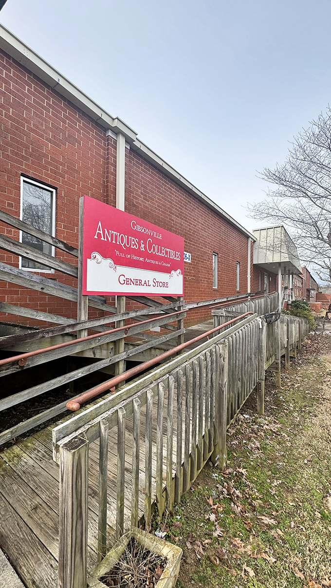 The unassuming brick fa&ccedil;ade with its vintage metal chairs and flamingo sentinel&mdash;proof that the best treasure maps often start with a simple "ANTIQUES" sign.
