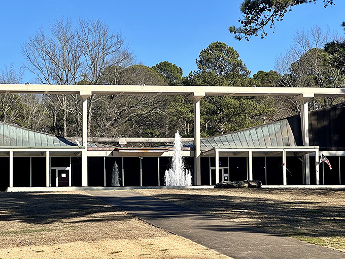 The modernist architecture of the Museum of Automobiles stands like a mid-century time capsule against Arkansas's lush greenery, complete with a welcoming fountain.
