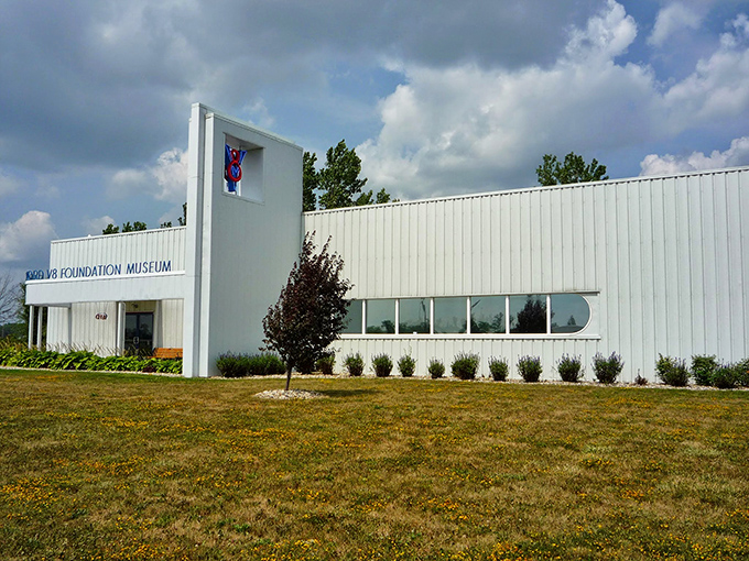 The sleek Art Deco-inspired exterior of the Early Ford V-8 Museum beckons car enthusiasts with its distinctive blue striping and retro styling. Automotive heaven awaits.