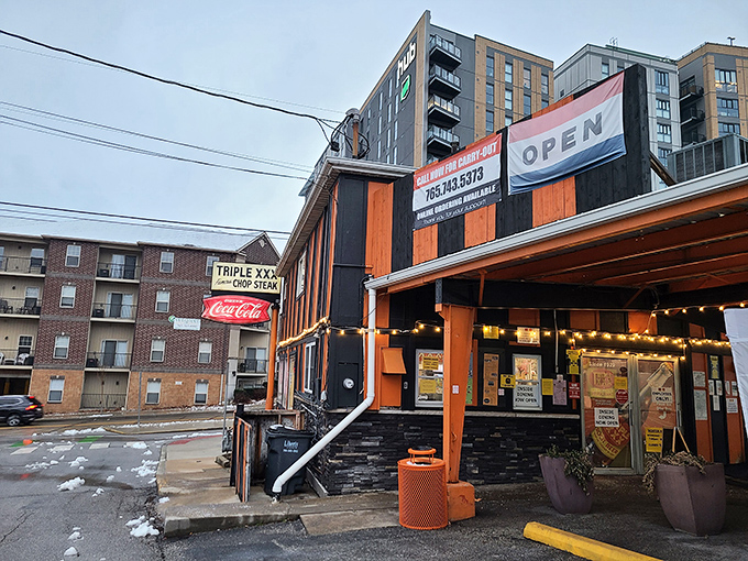 The iconic orange and black striped exterior stands defiant against modern architecture, like a time traveler who refuses to update their wardrobe. Pure Americana.
