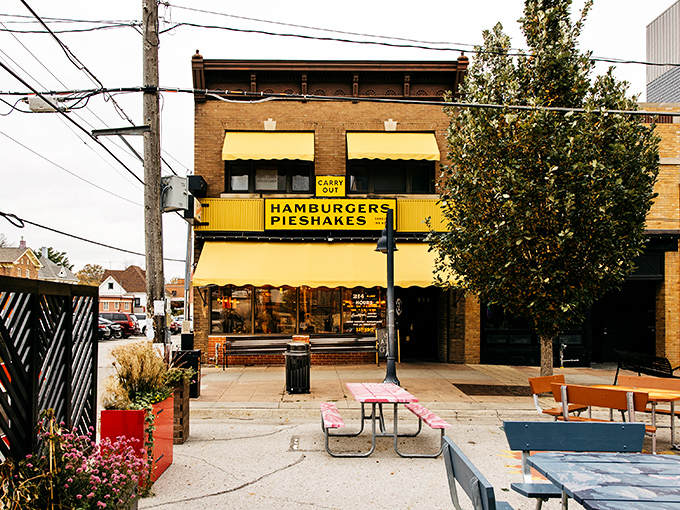 The iconic yellow awning of Hamburg Inn No. 2 stands as Iowa City's culinary lighthouse, beckoning hungry travelers with promises of "HAMBURGERS PIESHAKES" since 1948.