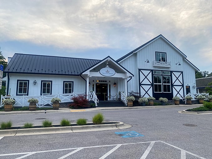 The farmhouse-chic exterior of Blackwall Barn & Lodge stands like a culinary lighthouse in Gambrills, beckoning hungry travelers with its pristine white siding and elegant black roof.