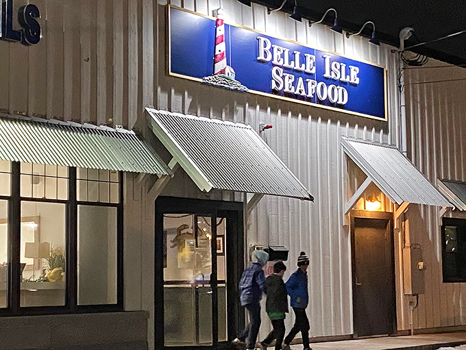 The unassuming exterior of seafood paradise – where luxury cars and work trucks share parking spaces in democratic pursuit of lobster perfection.