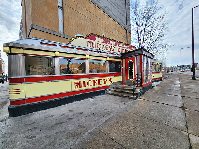 Mickey's iconic red and cream exterior stands like a time capsule on St. Paul's street corner, beckoning hungry travelers with its neon promise of comfort food.