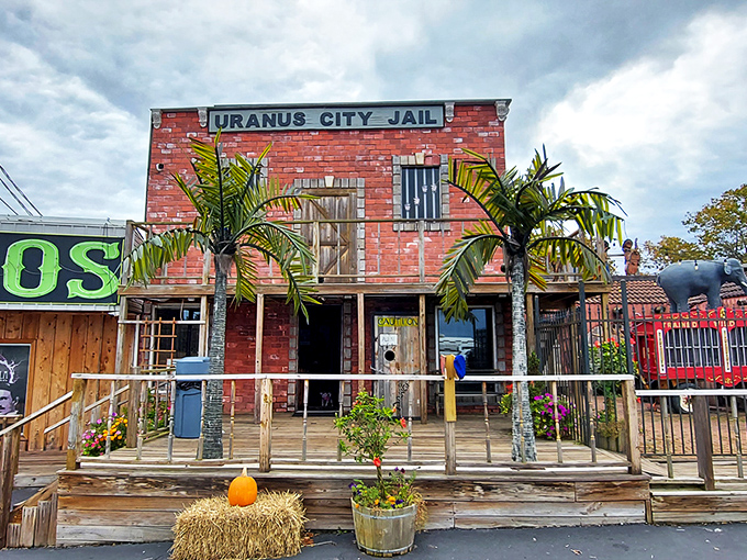 The "Uranus City Jail" facade perfectly captures the attraction's commitment to frontier-themed humor. Palm trees and hay bales create an unexpected Missouri oasis of quirky roadside charm.