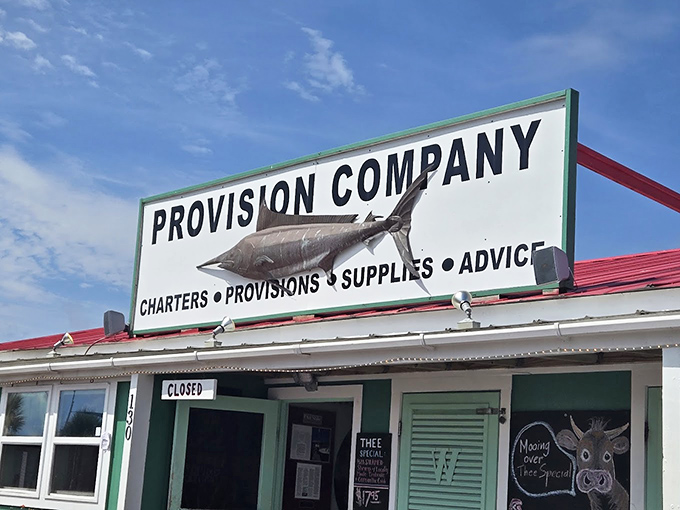 The unassuming entrance to seafood paradise – where that weathered fish sign promises more flavor than any fancy neon ever could.