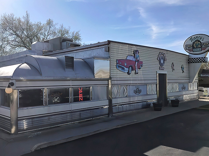 The gleaming silver exterior of Nancy's Main Street Diner stands like a time capsule on wheels, complete with vintage signage and classic car artwork.