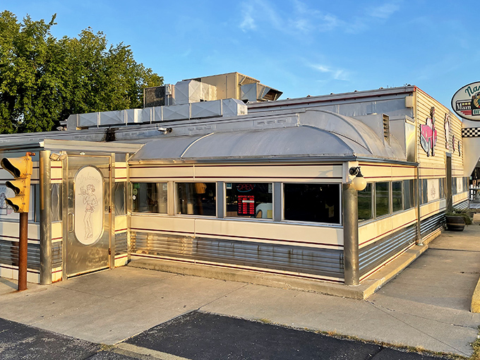 The gleaming silver exterior of Nancy's Main Street Diner stands like a time capsule on wheels, complete with vintage signage and classic car artwork.
