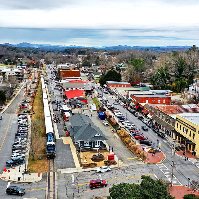 Blue Ridge unfolds like a storybook mountain town from above, its charming streets nestled among endless rolling green hills that seem to stretch into forever.