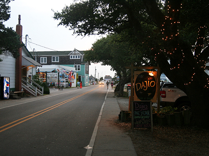 Ocracoke's main street at dusk feels like stepping into a storybook &ndash; where every shop has a tale and string lights guide your way home.