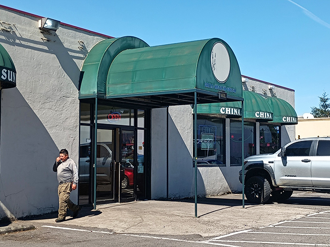 The distinctive green awnings of China Sun Buffet stand out against the white exterior, like beacons guiding hungry travelers to their destination.