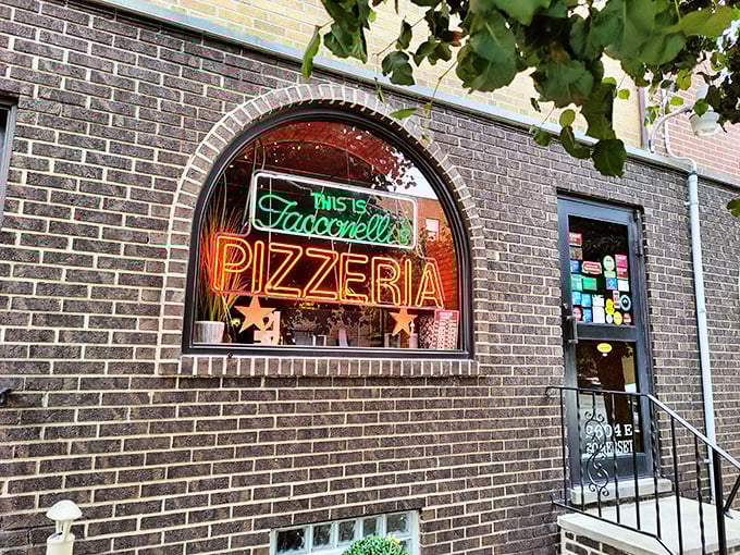 The neon glow of Tacconelli's sign beckons pizza pilgrims like a lighthouse for the carb-obsessed. Pizza paradise awaits behind that brick facade. 