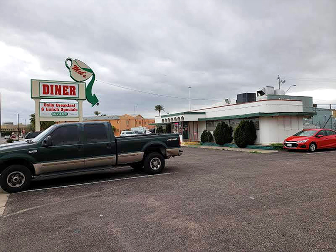 The classic roadside silhouette of Mel's Diner stands proudly against Arizona's impossibly blue sky, a time capsule of Americana waiting to welcome hungry travelers.