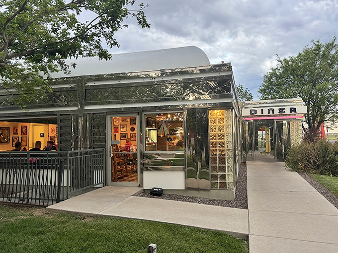 The classic silver exterior of Moonlight Diner gleams in the Colorado sunshine, a chrome time capsule promising comfort food and nostalgia just steps from Denver International Airport.